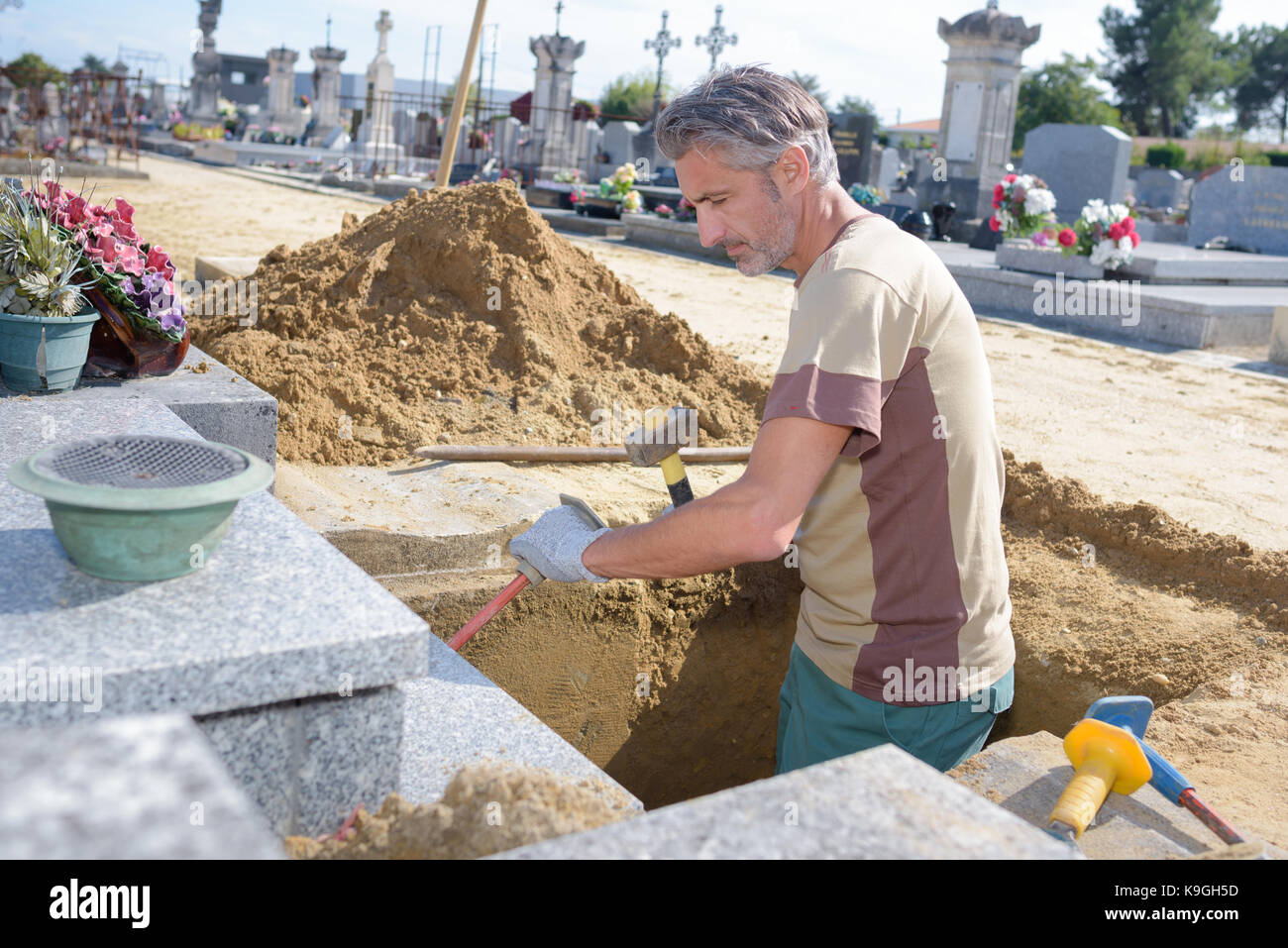 caucasian man digging grave at cemetery Stock Photo - Alamy