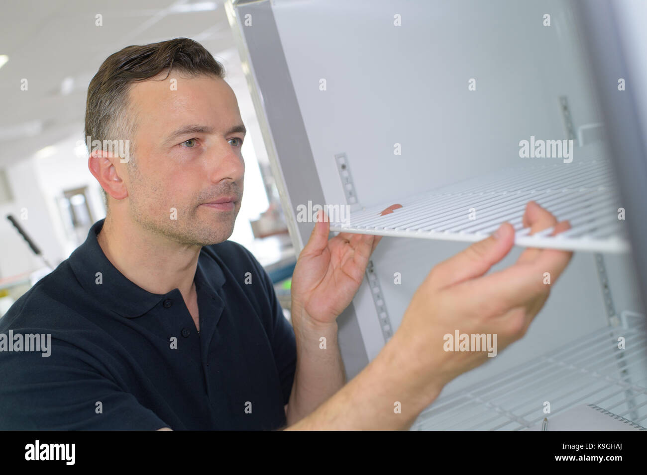 man installing guide rails for shelves Stock Photo - Alamy