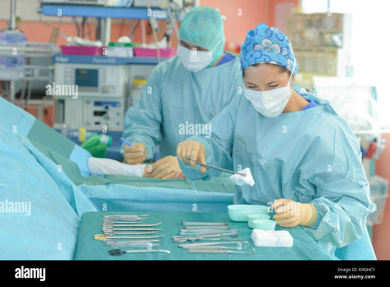 two surgeons bending over a patient Stock Photo - Alamy