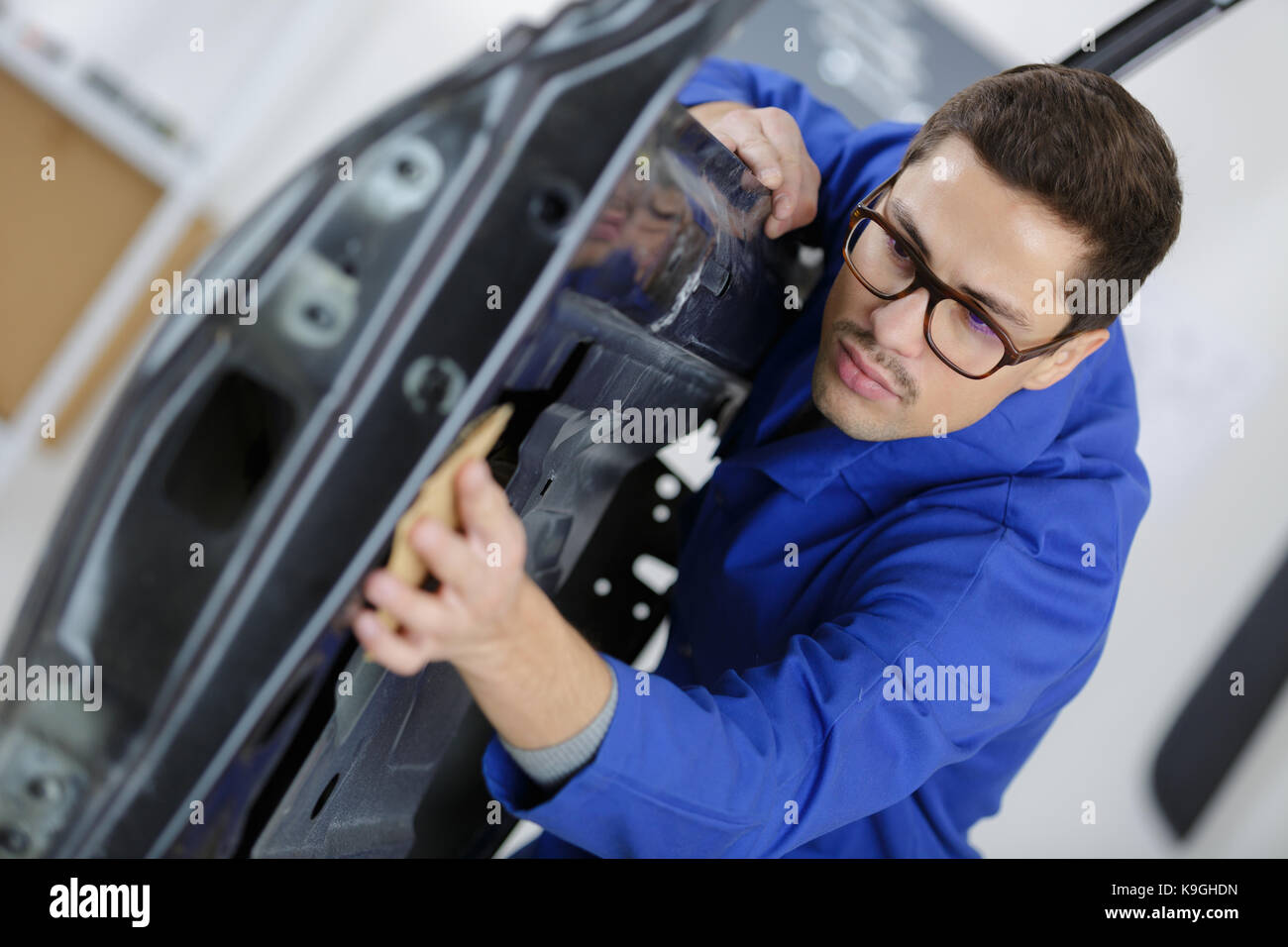 portrait of handsome mechanic in uniform cleaning car door Stock Photo ...