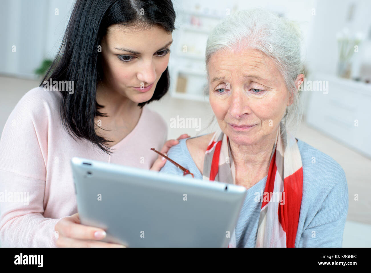 helping old woman use a tablet computer Stock Photo - Alamy