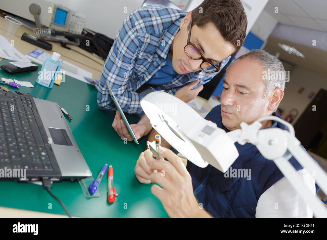 two handsome engineers working on electronics components Stock Photo ...