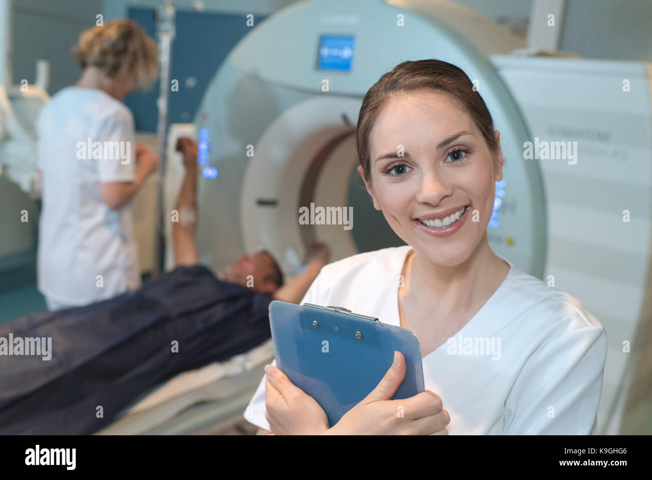 doctor instructing technician while preparing patient for mri scan ...