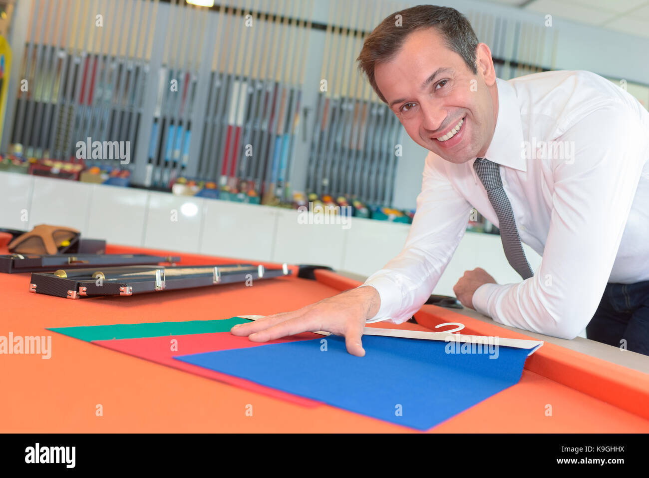 young handsome seller leaning over pool table Stock Photo - Alamy