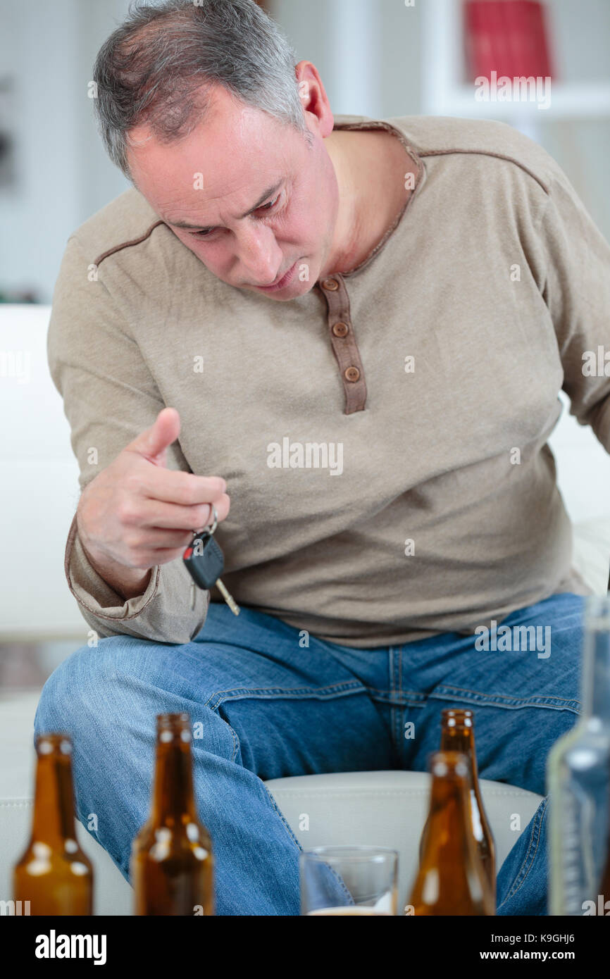 young drunk man with car key and bottle of beer Stock Photo - Alamy
