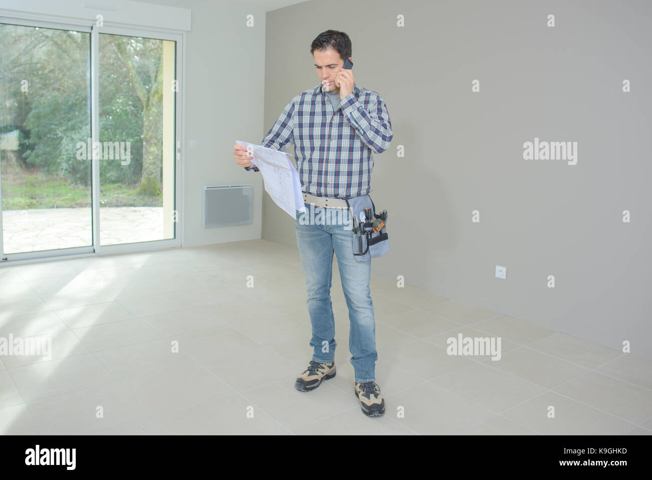architect inspecting a blueprint while at the construction site Stock ...