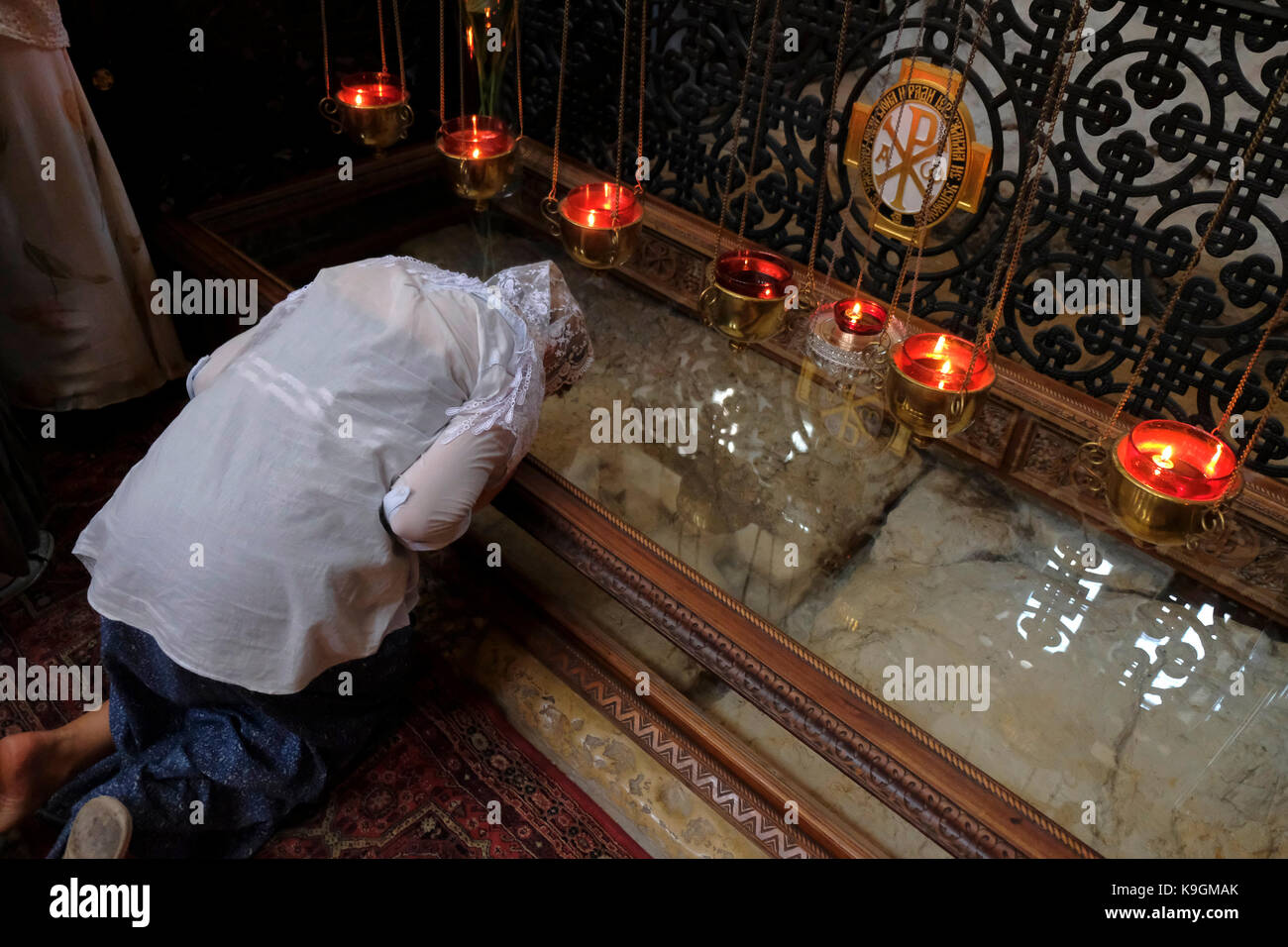A Russian Orthodox pilgrim praying over remains of the “Judgement Gate ...
