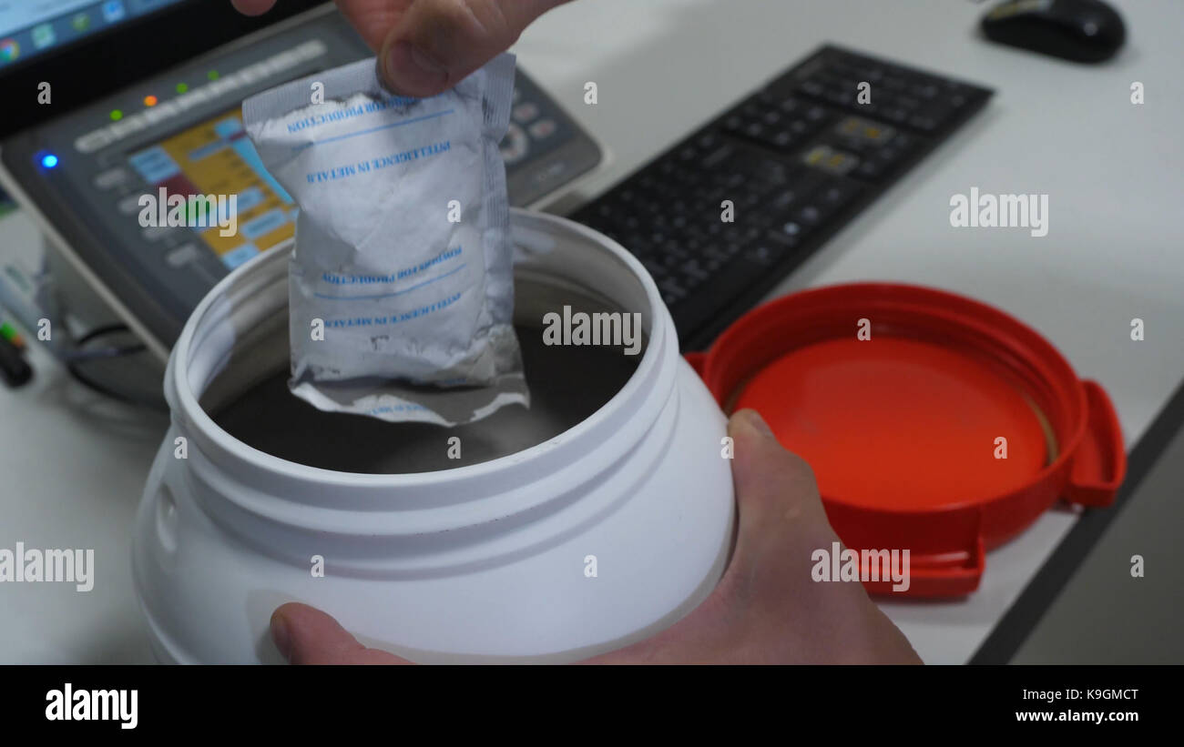 Chemical scientist opening white unlabeled plastic tank canister with ...