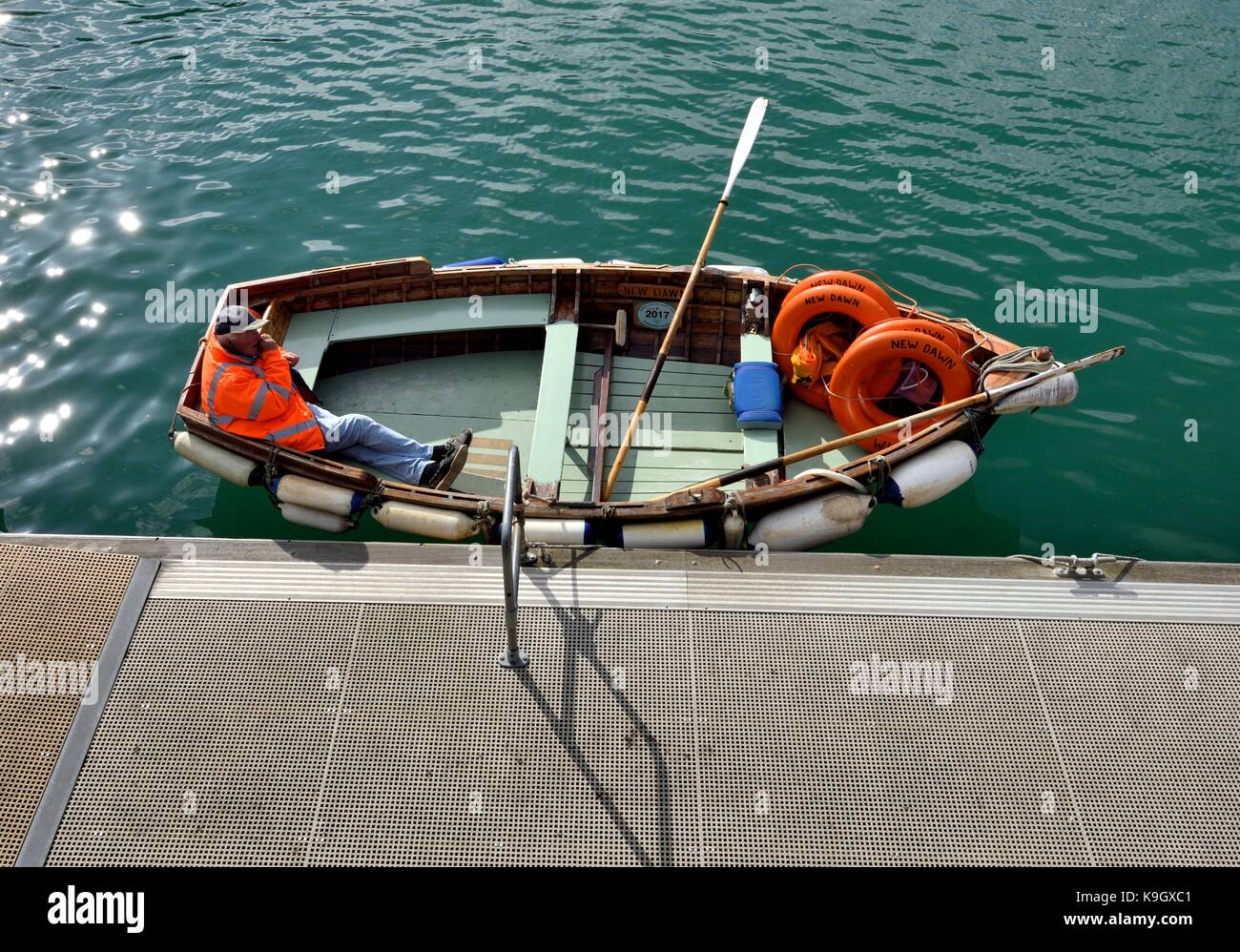 Senior elderly lady taking a trip in a water taxi ferry rowing boat ...