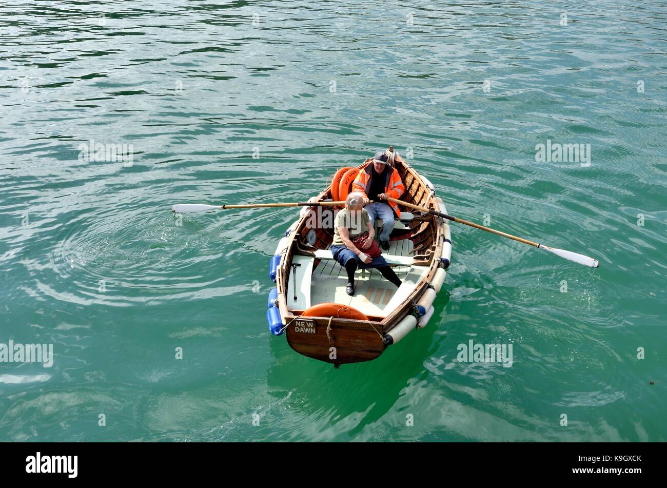 Senior elderly lady taking a trip in a water taxi ferry rowing boat ...