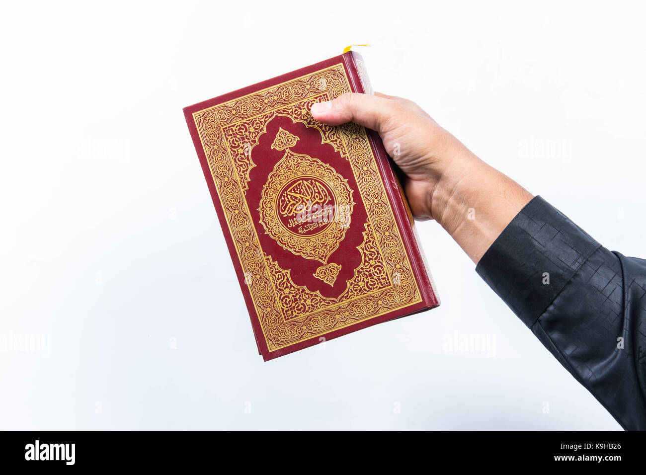 Koran in hand , Quran in hand - holy book of Muslims , on white ...