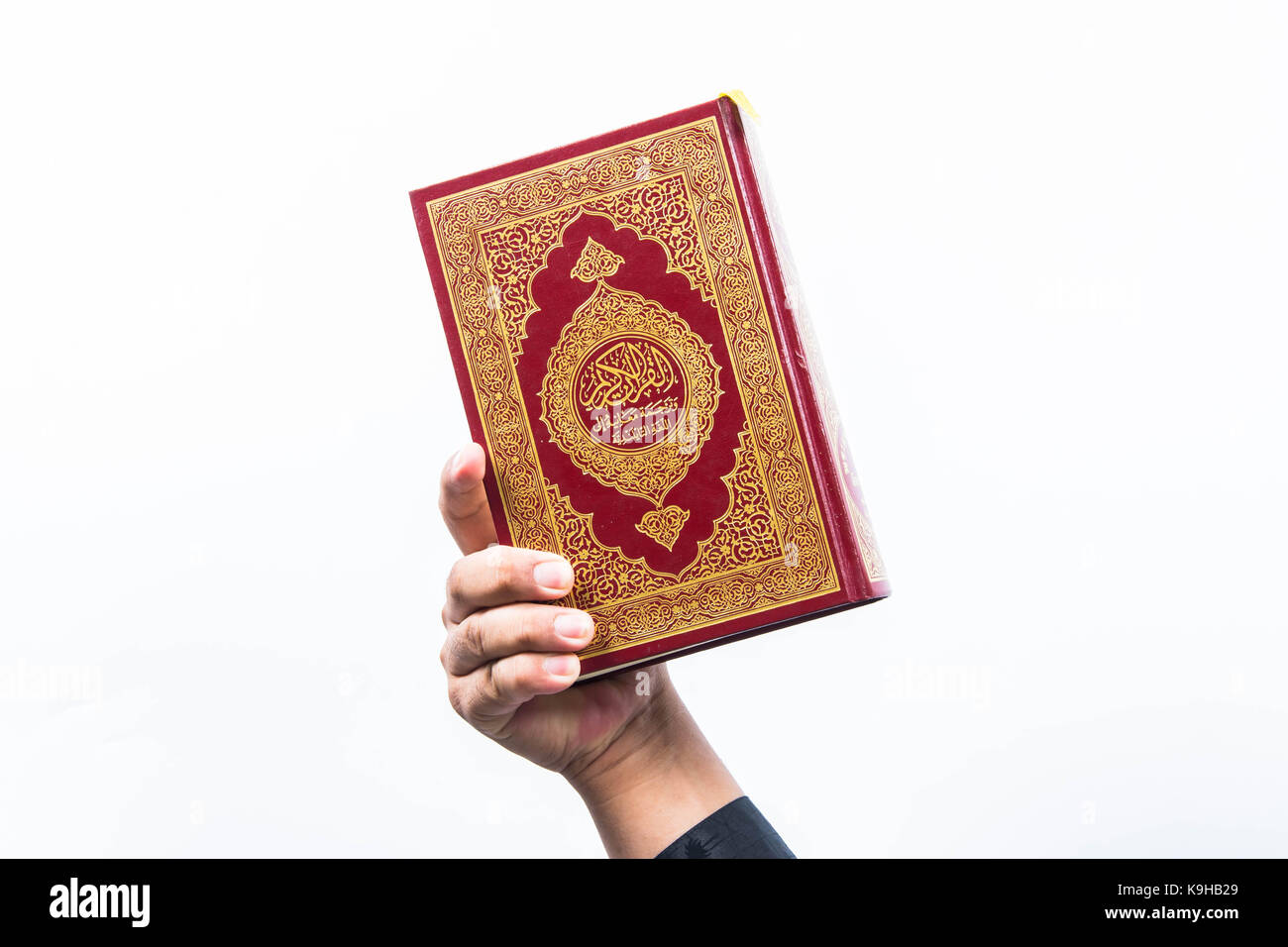 Koran in hand , Quran in hand - holy book of Muslims , on white ...