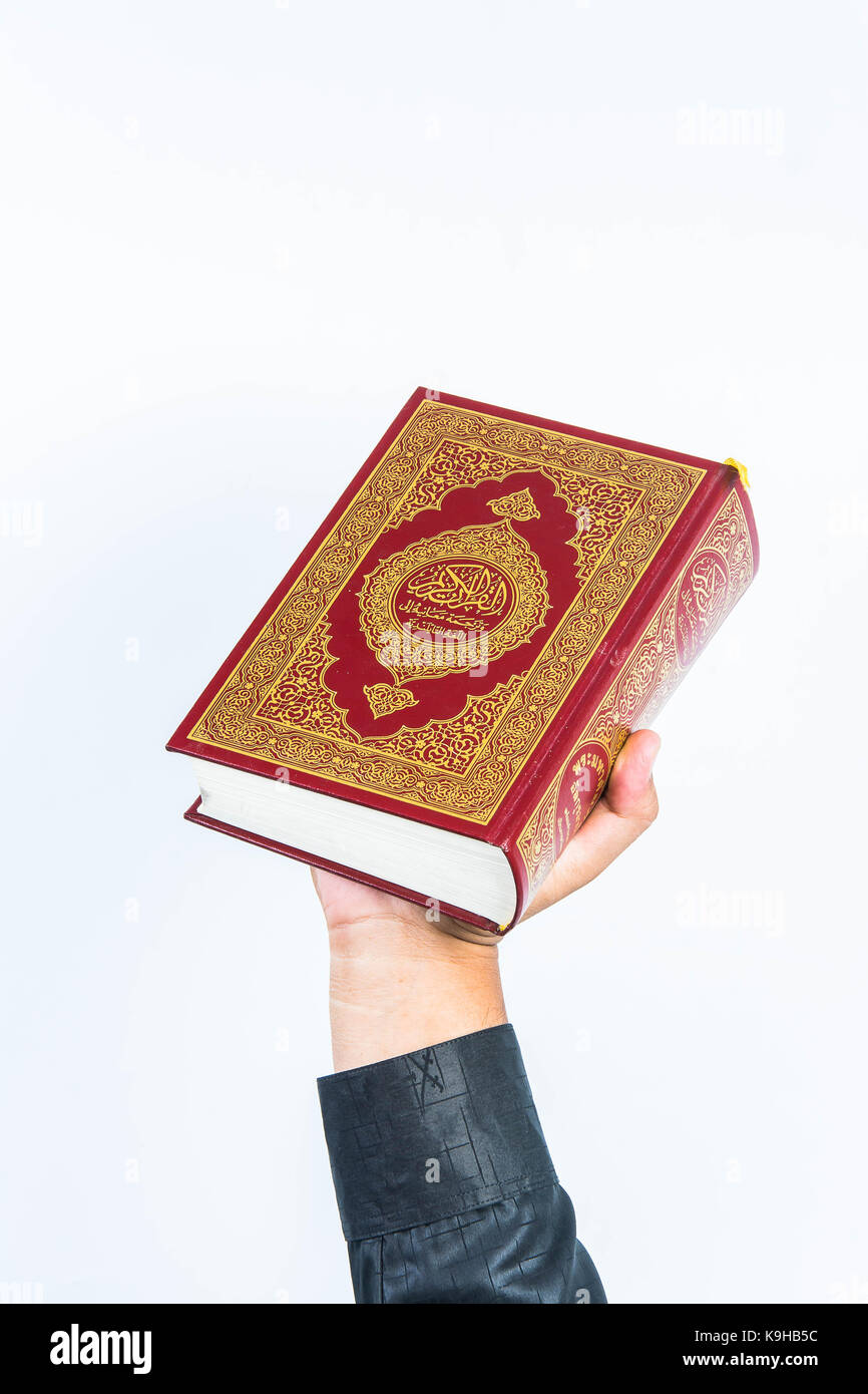 Koran in hand , Quran in hand - holy book of Muslims , on white ...