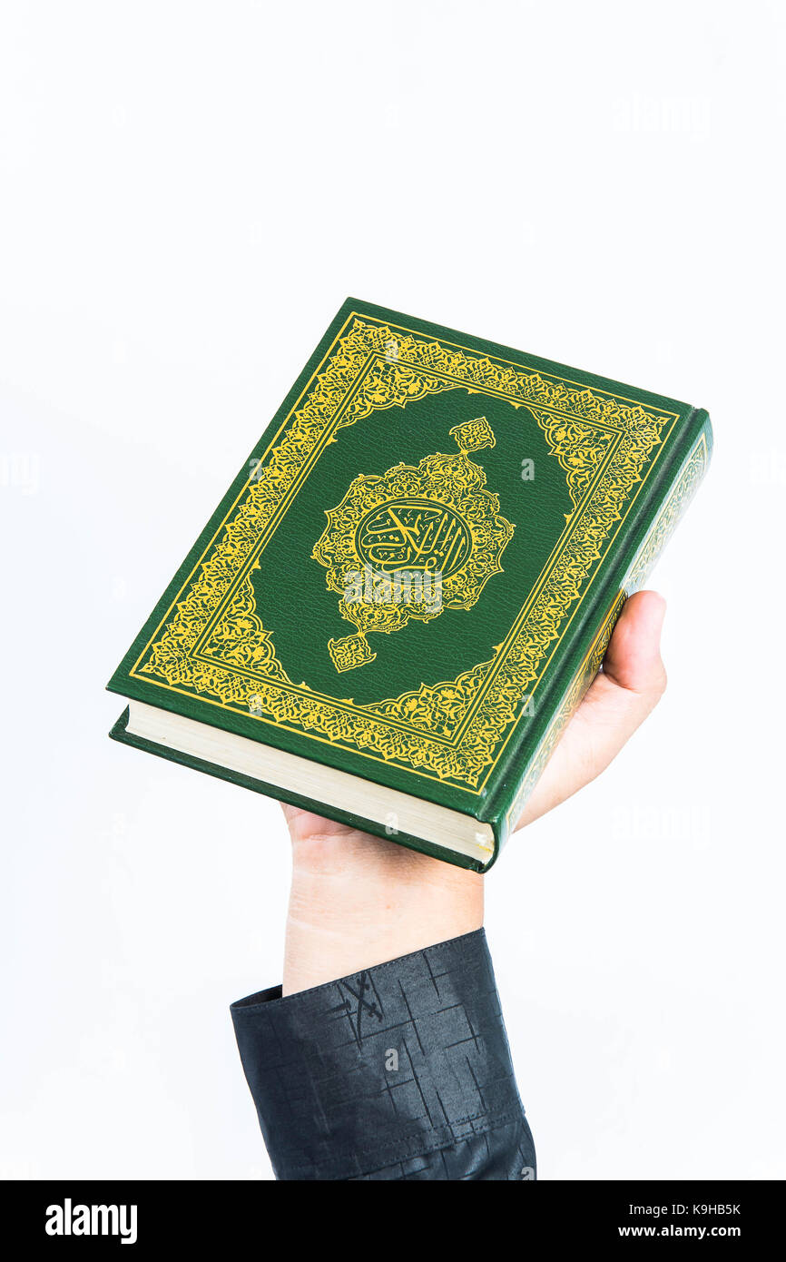 Koran in hand , Quran in hand - holy book of Muslims , on white ...