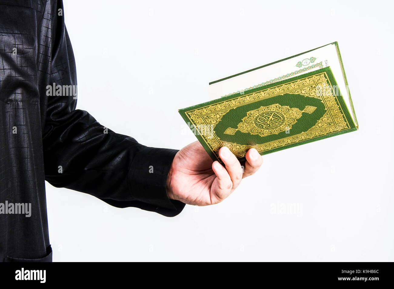 Koran in hand , Quran in hand - holy book of Muslims , on white ...