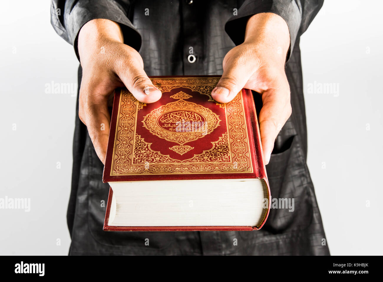 Koran in hand , Quran in hand - holy book of Muslims , on white ...