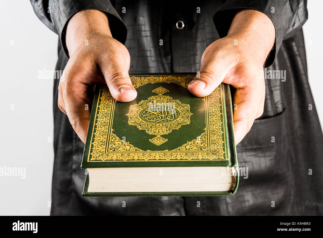 Koran in hand , Quran in hand - holy book of Muslims , on white ...