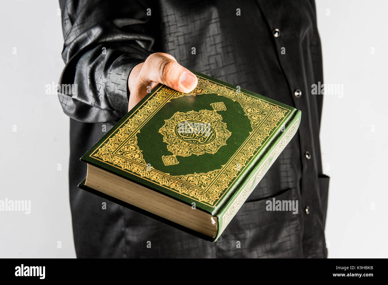 Koran in hand , Quran in hand - holy book of Muslims , on white ...