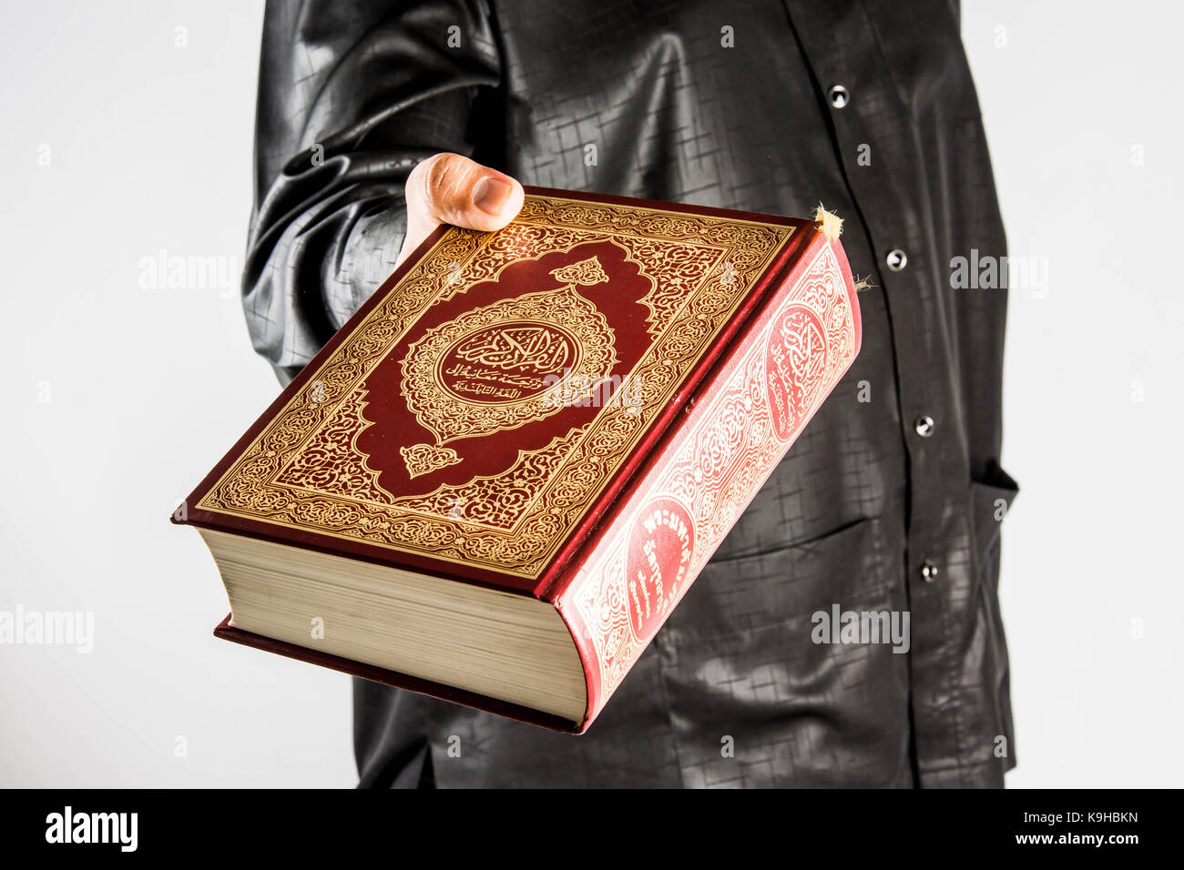 Koran in hand , Quran in hand - holy book of Muslims , on white ...
