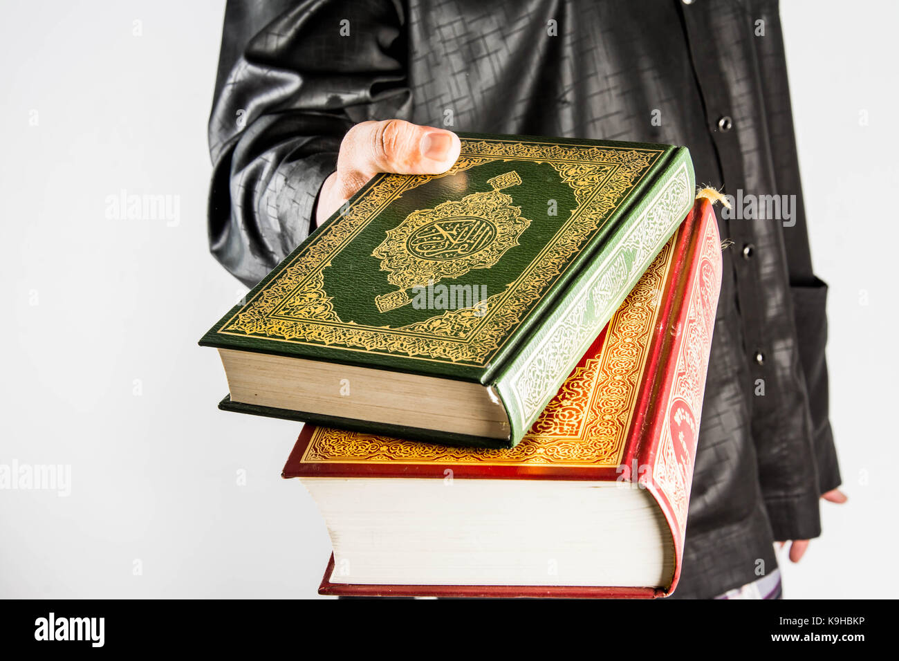 Koran in hand , Quran in hand - holy book of Muslims , on white ...