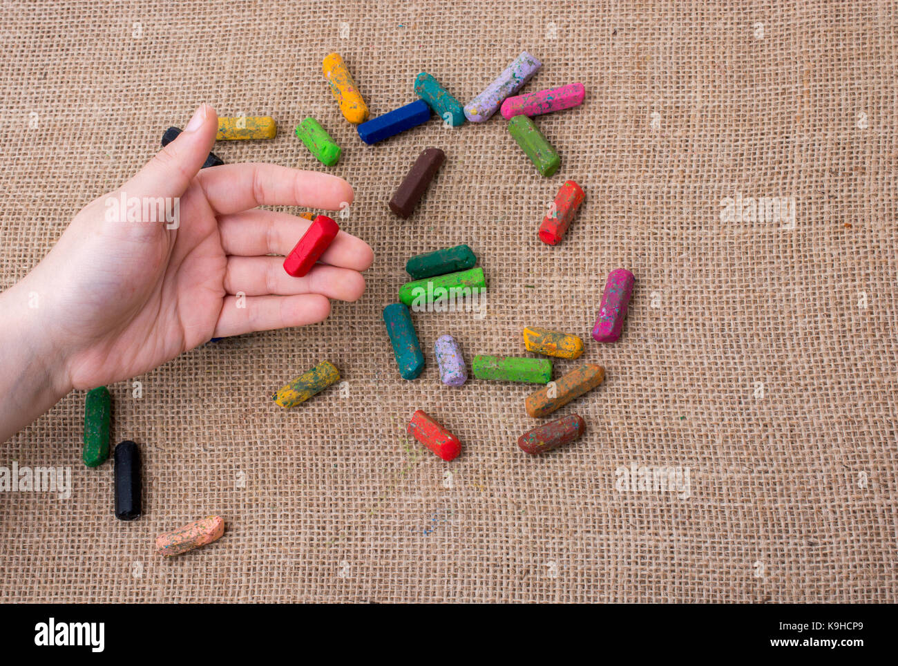 Used color crayons and a hand holding one Stock Photo - Alamy