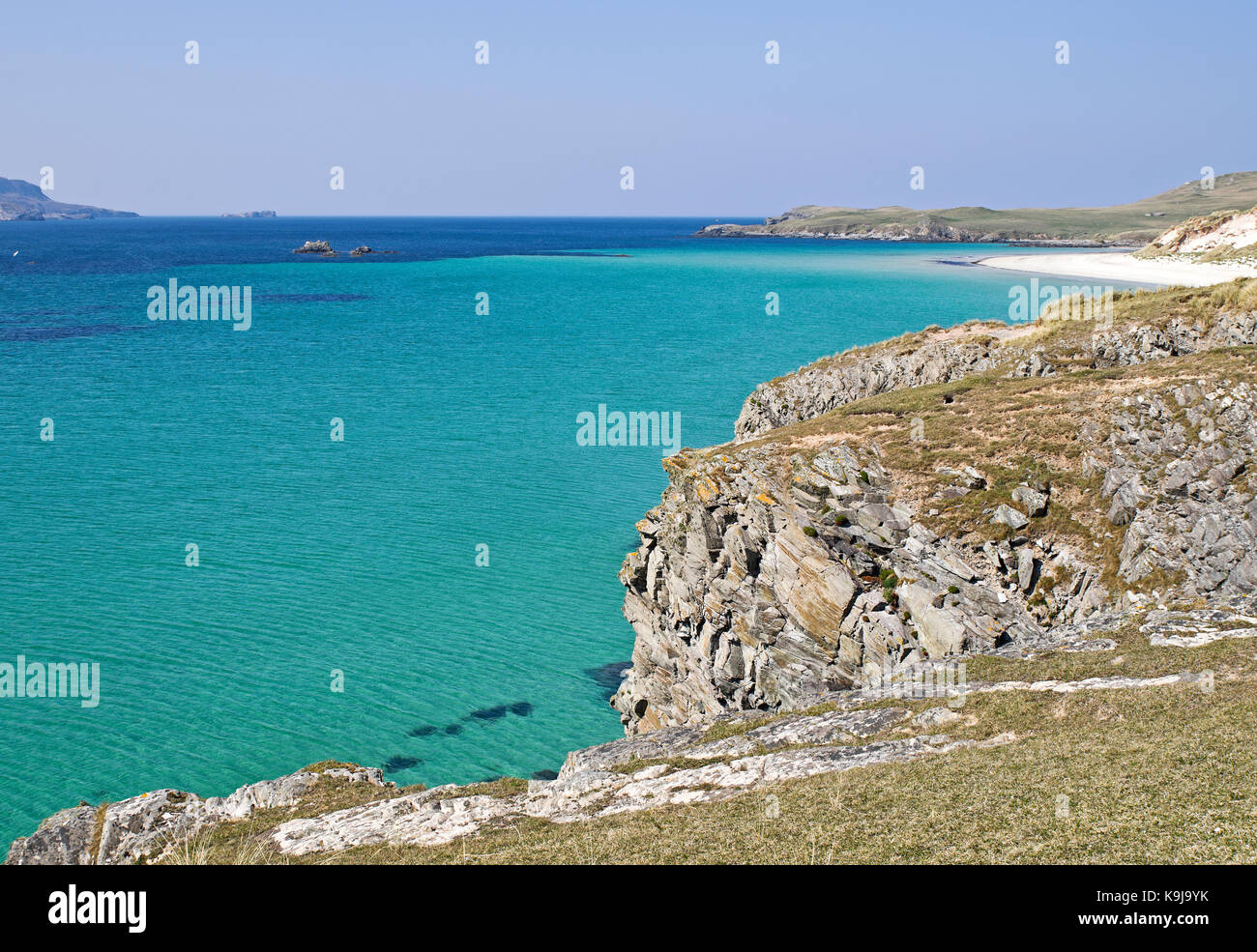 View from a cliff over the turquoise coloured sea and white sand beach ...