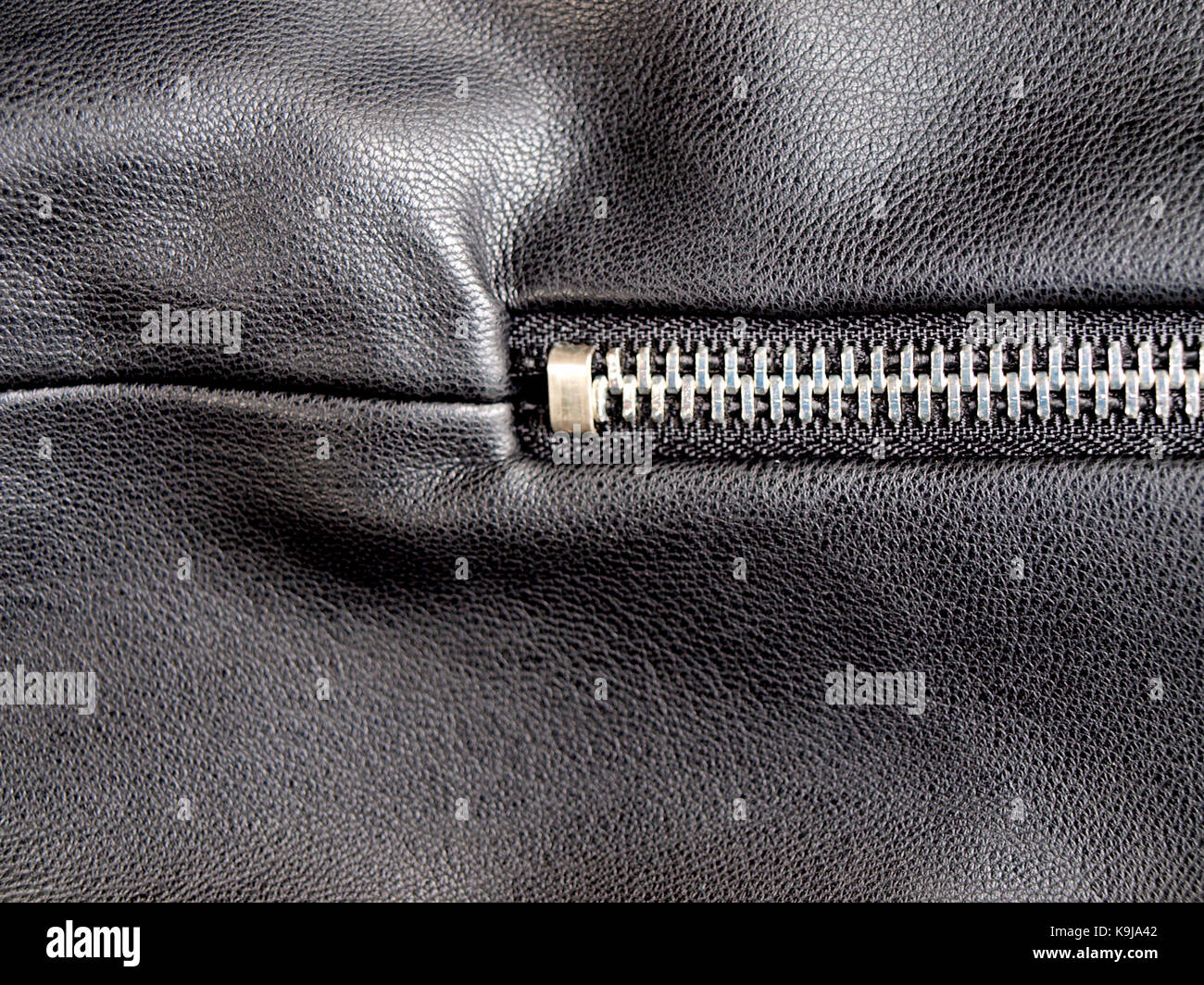 Silver zipper in black leather Stock Photo - Alamy