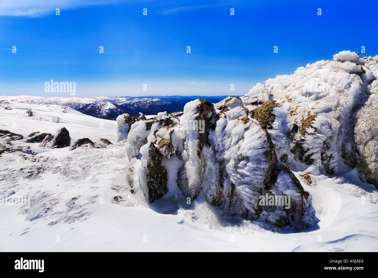 Top of Back Perisher mountain with ice covered mossy boulders on a ...