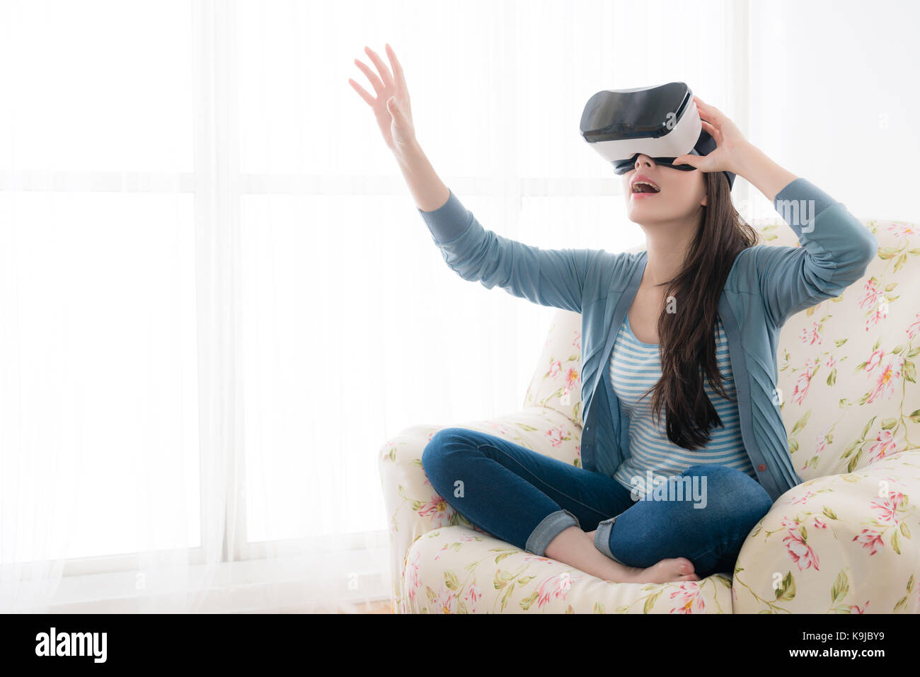 happy beauty woman sitting on sofa chair wearing virtual reality ...