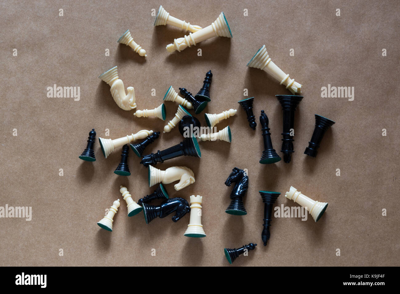 Chess pieces scattered in a random manner on a brown background lying ...