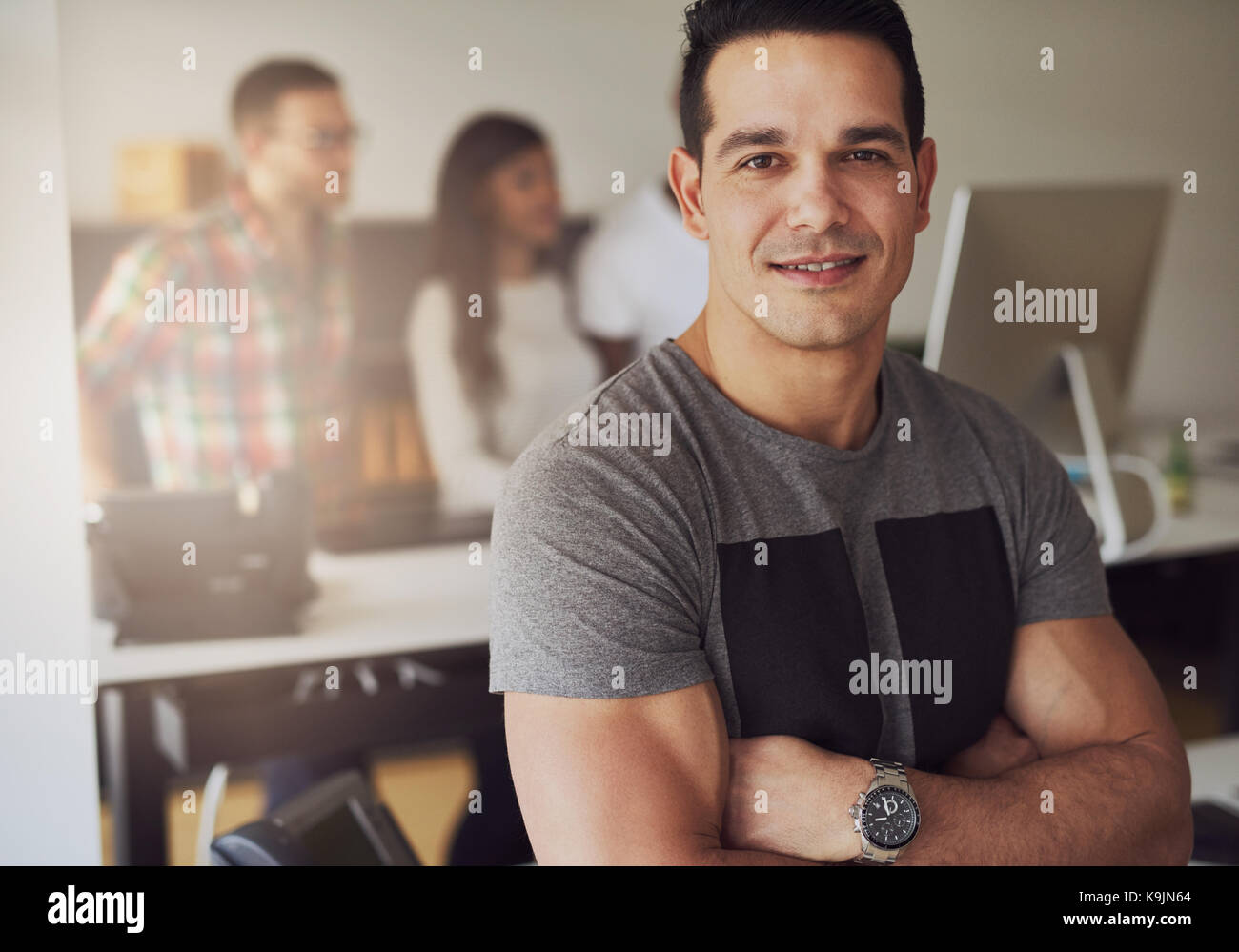 Confident young male entrepreneur looking at camera and standing in ... Confident young male entrepreneur looking at camera and standing in ...