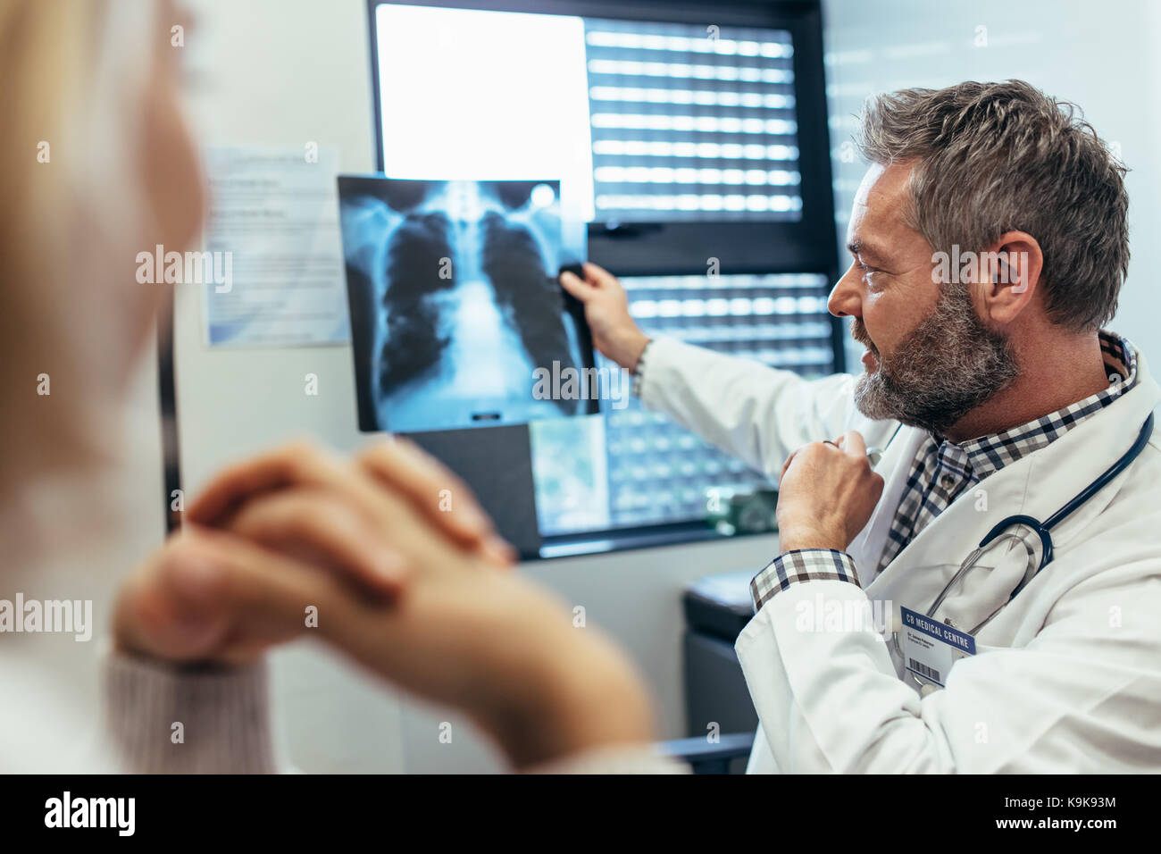 Doctor discussing scan results with patient in clinic. Male radiologist ...