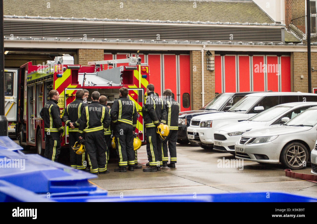 A group of Londo firefighters gather round their fire engine at a fire ...
