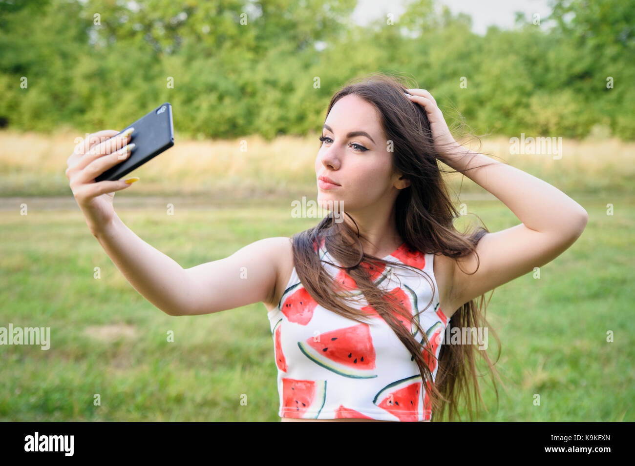Young beautiful girl doing selfie at sunset Stock Photo - Alamy