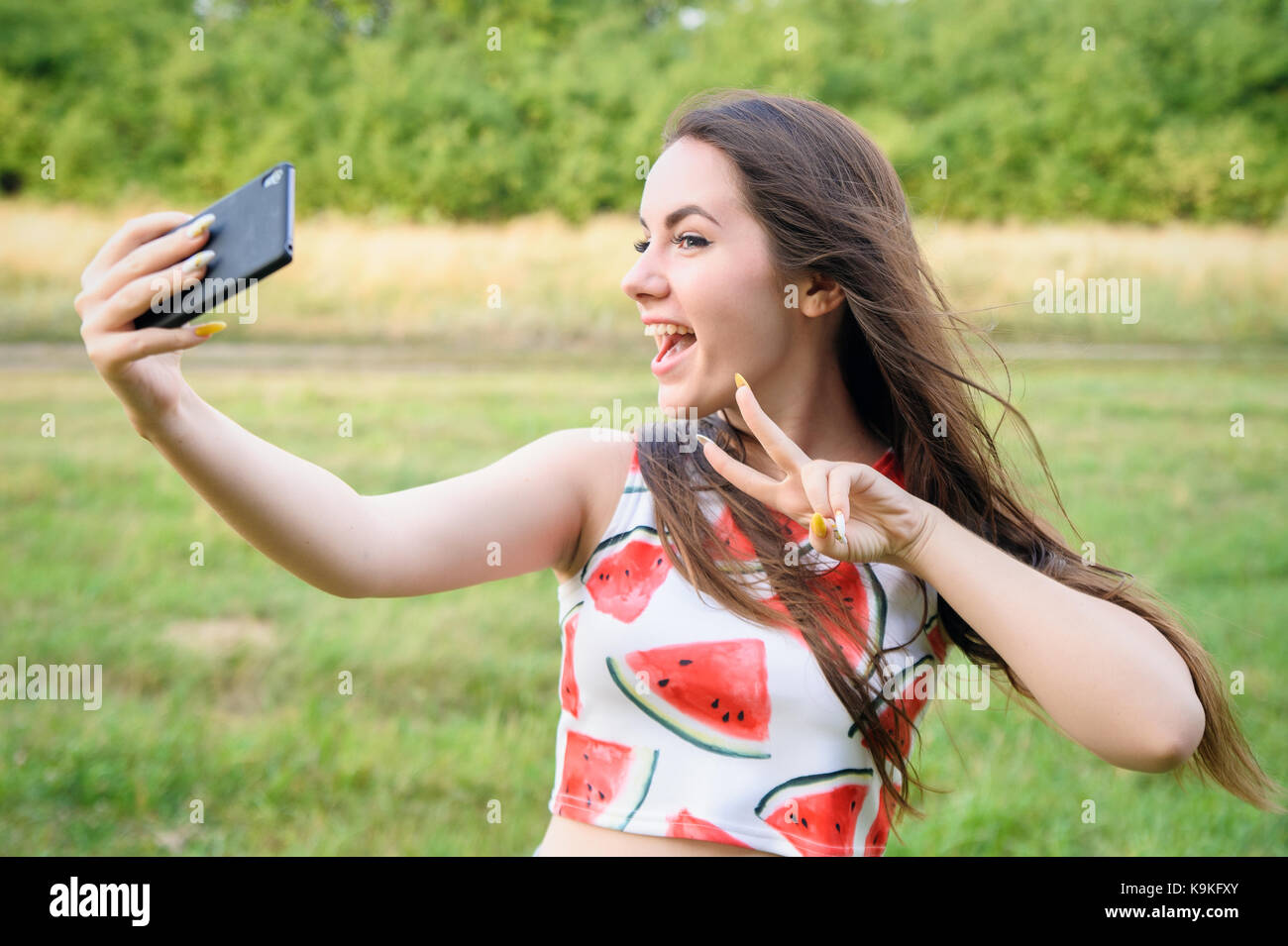 Young beautiful girl doing selfie at sunset Stock Photo - Alamy