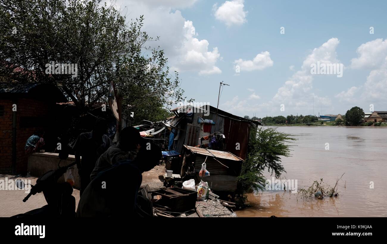 Phnom Penh Cambodia Monivong Bridge Bassac River Slum Area lady cutting ...