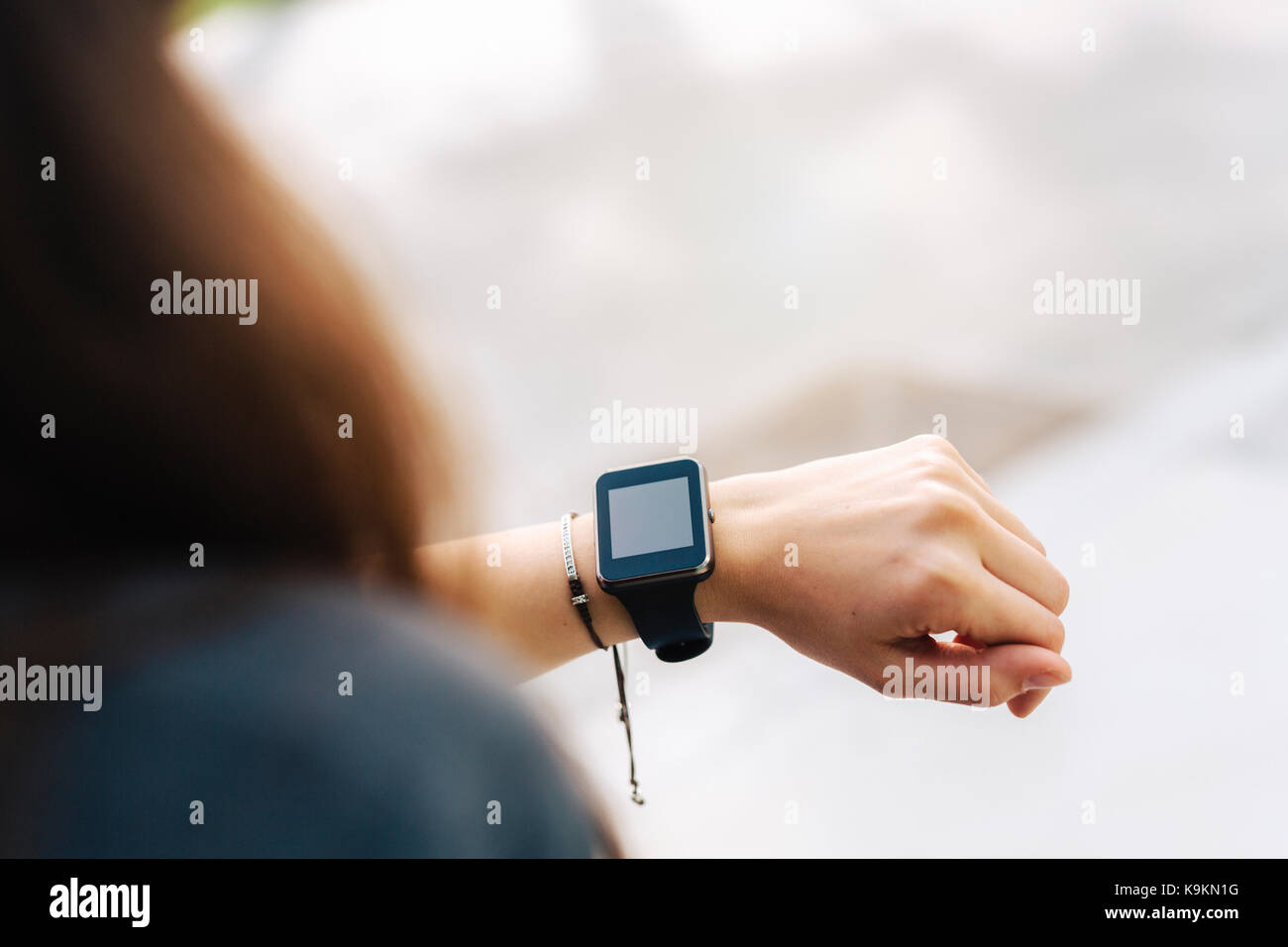 Woman checking her smartwatch Stock Photo - Alamy