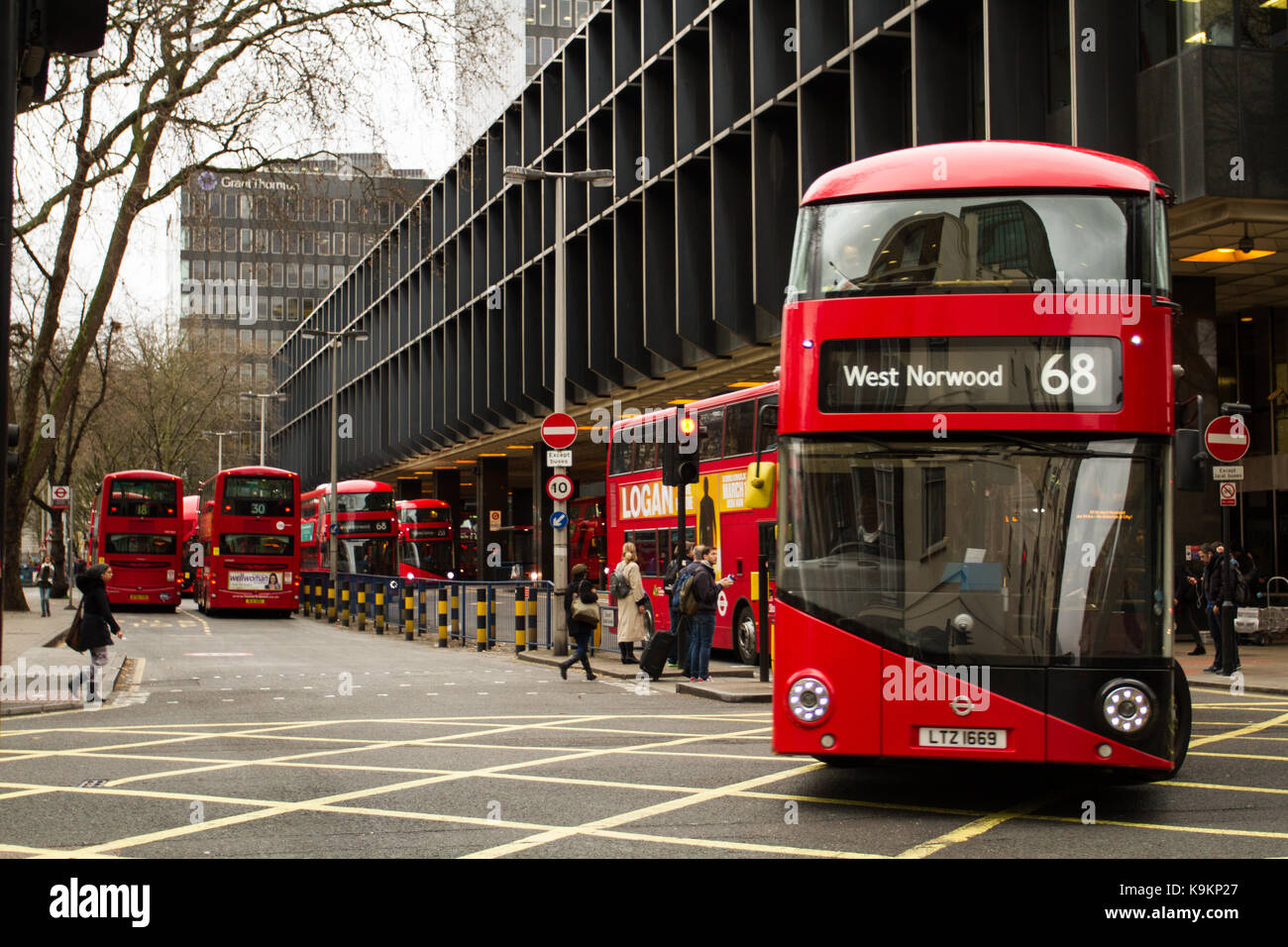 A red, London Routemaster double decker bus departing a packed Euston ...