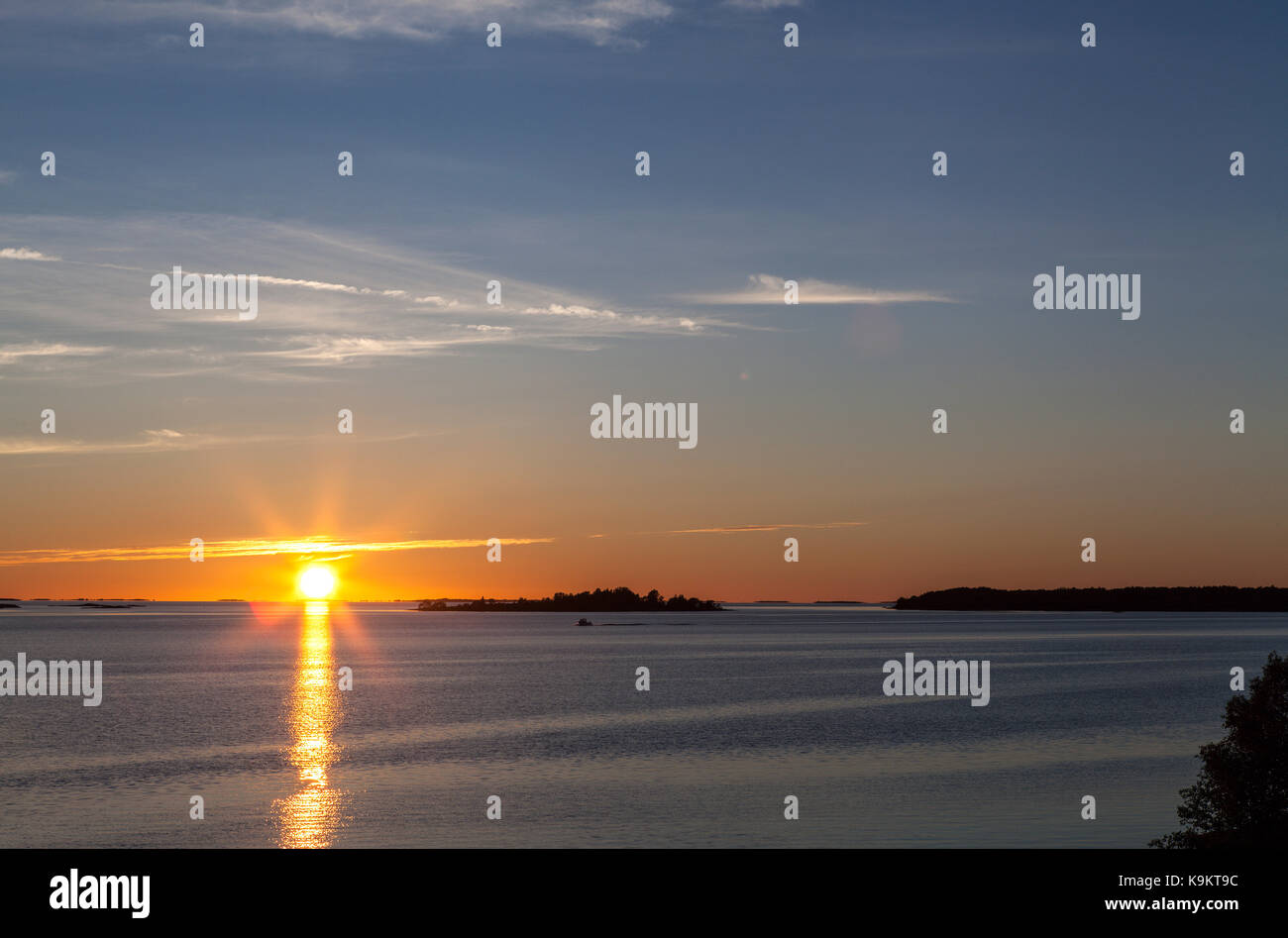 Sunset in the sea. Islands at the horizon Stock Photo - Alamy