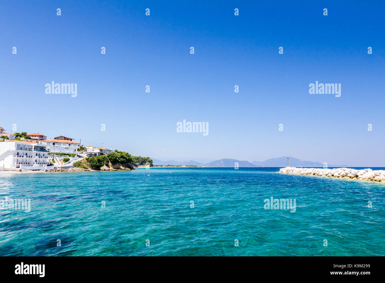 Rocky shallows with crystal clear water and beautiful settlement over ...
