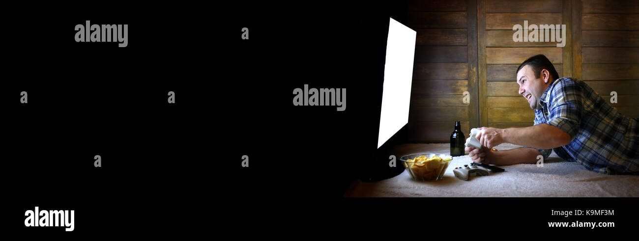 man playing on a console on the joystick before the big TV scree Stock ...