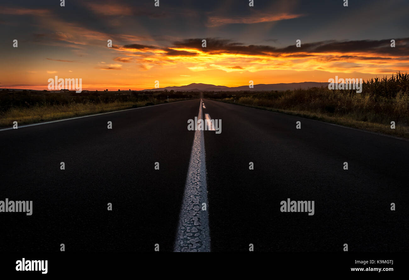 Straight highway road to a dramatic fiery sunset Stock Photo - Alamy