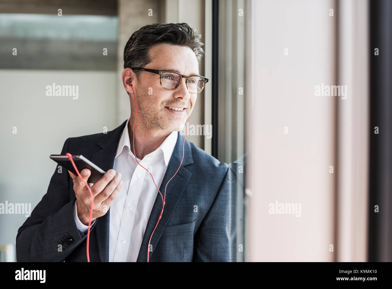 Portrait of businessman standing speaking notes on smartphone while ...