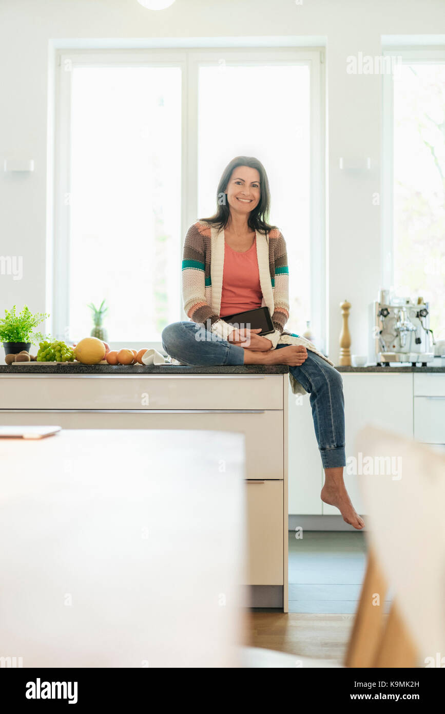 Woman alone sitting on kitchen counter hi-res stock photography and ...