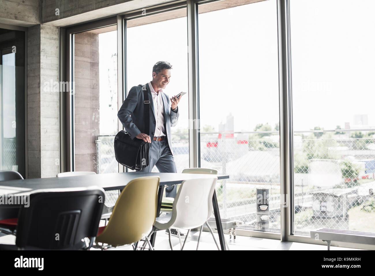 businessman standing by window, making a phone call Stock Photo - Alamy
