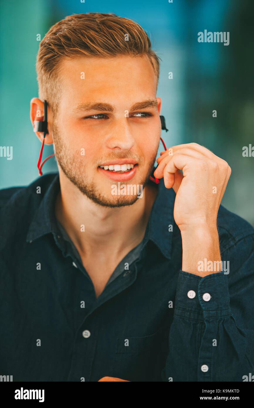 Young man wearing headset outdoors Stock Photo - Alamy