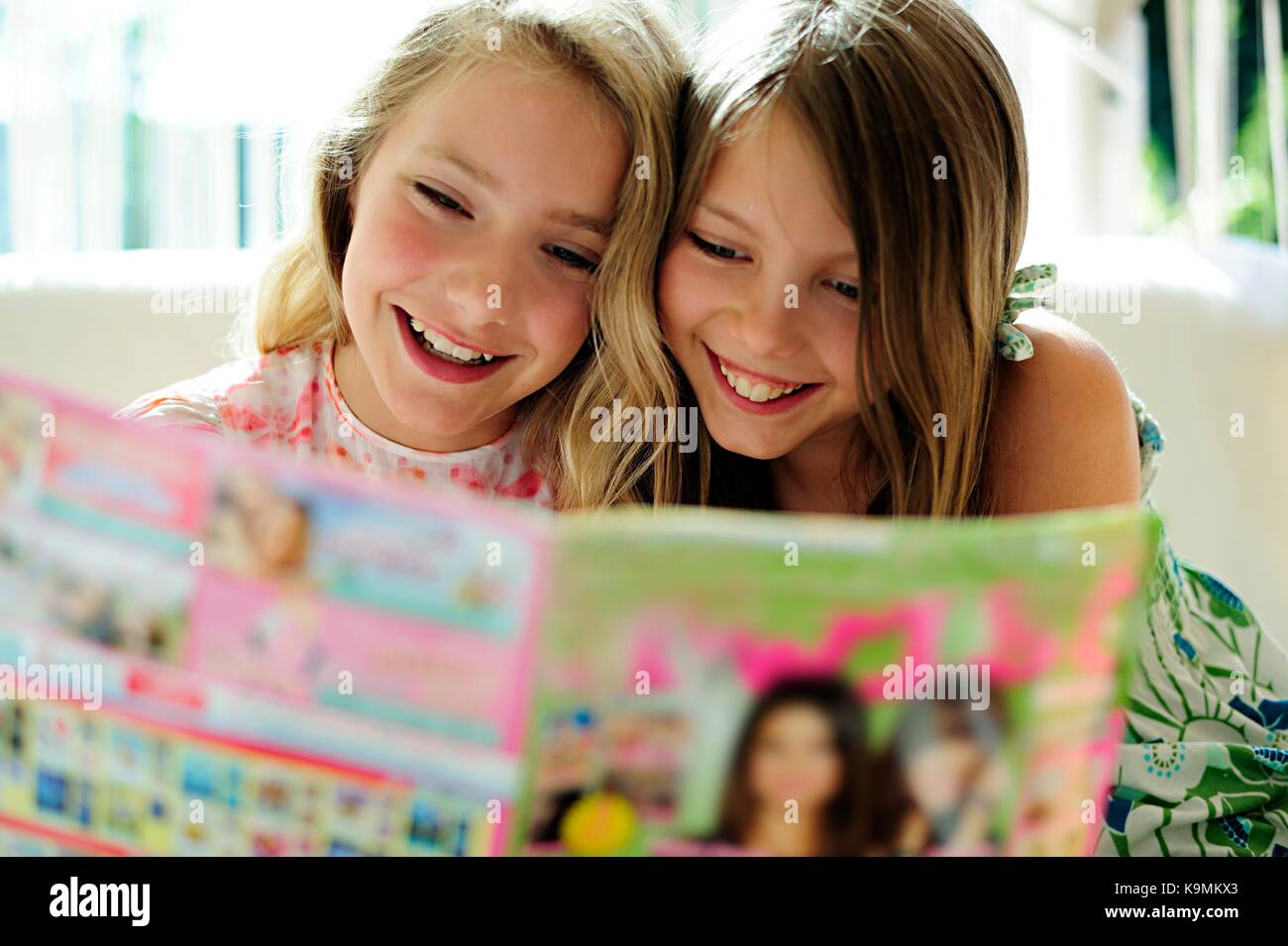 Two girls reading teen magazine Stock Photo - Alamy