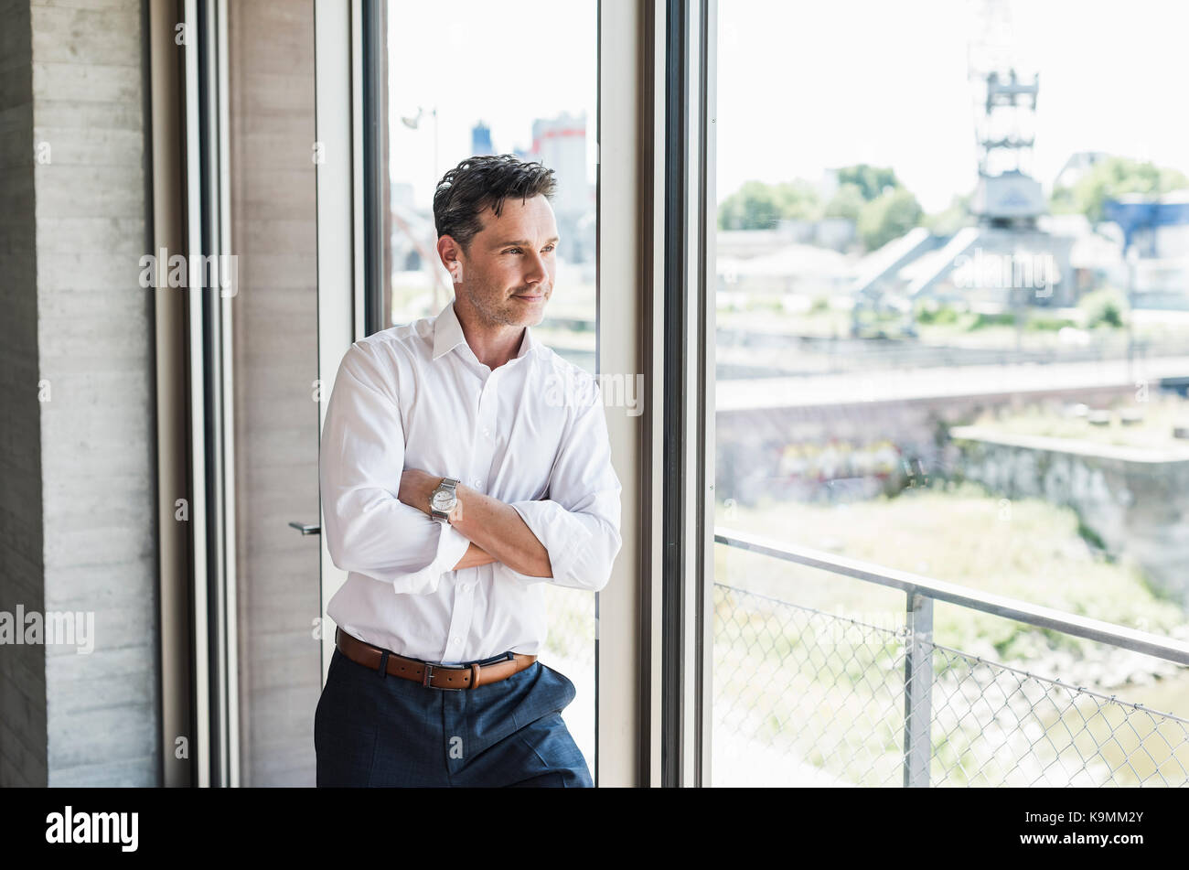 Businessman standing window looking distance hi-res stock photography ...