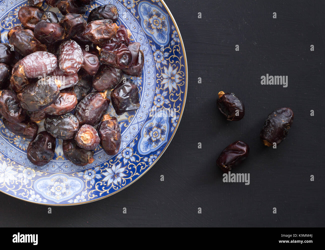 Top view of organic ready to eat dates in ornate blue and gold middle ...