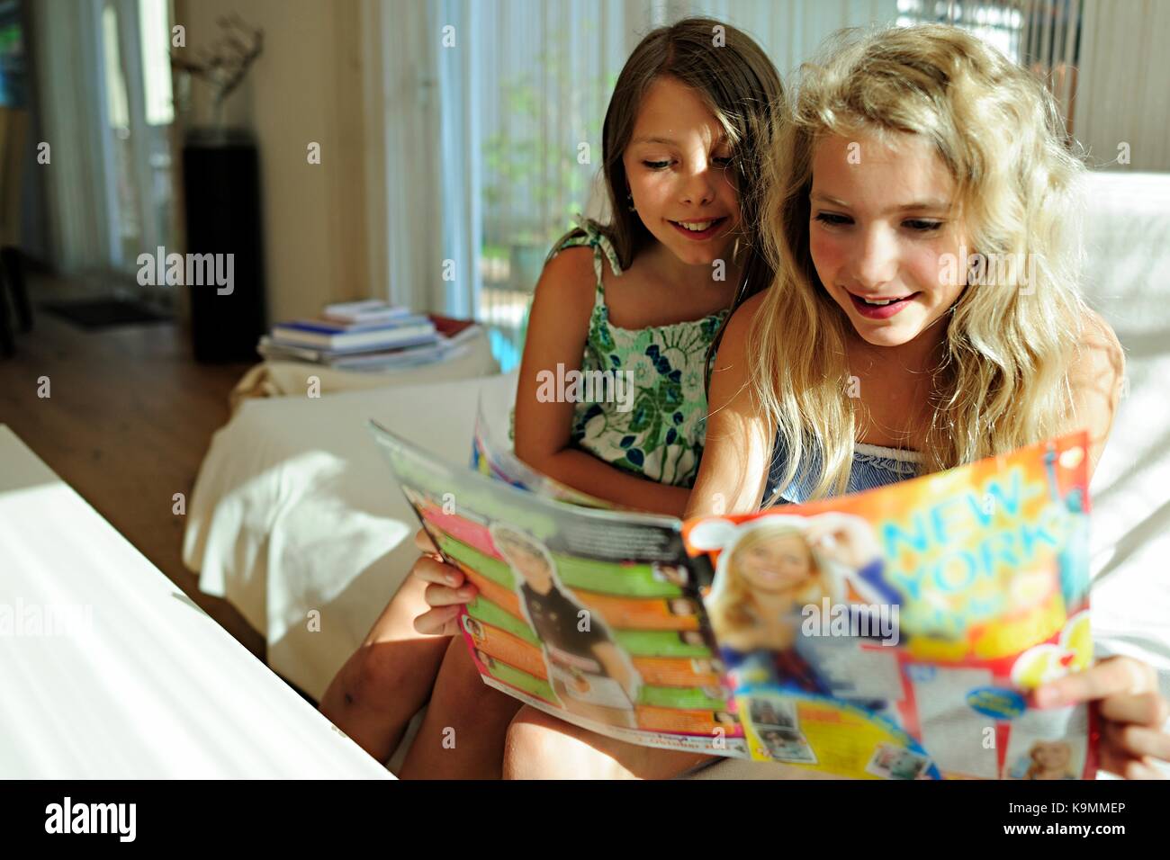 Two girls reading teen magazine Stock Photo - Alamy